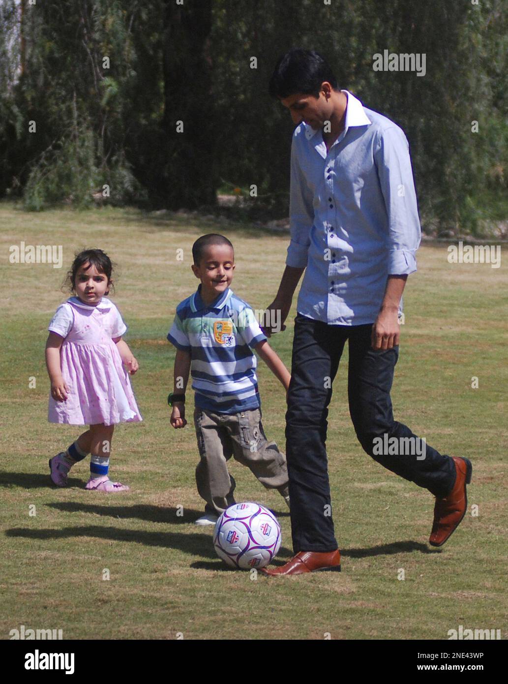 British boy Sahil Saeed, center, plays soccer with his father Raja ...