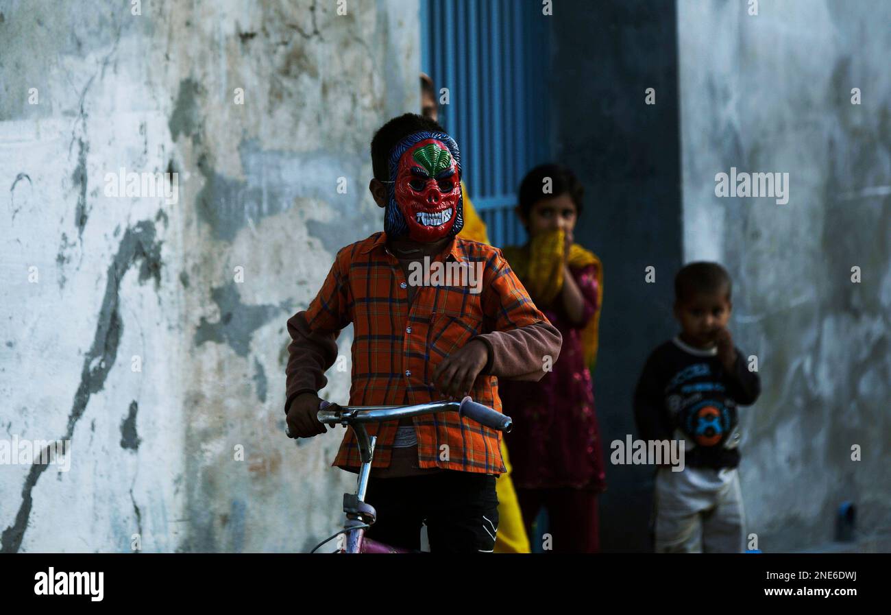 A Pakistani youth, is seen wearing a mask next to the house of ...