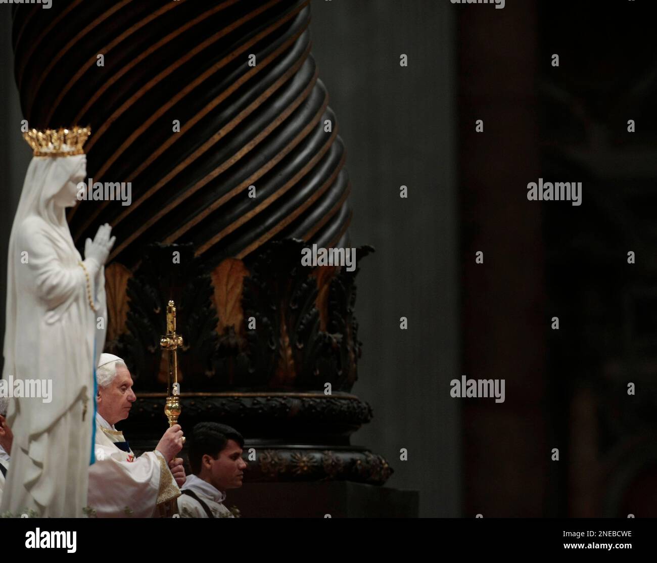 Pope Benedict XVI, framed by the statue of the Virgin Mary, holds the ...