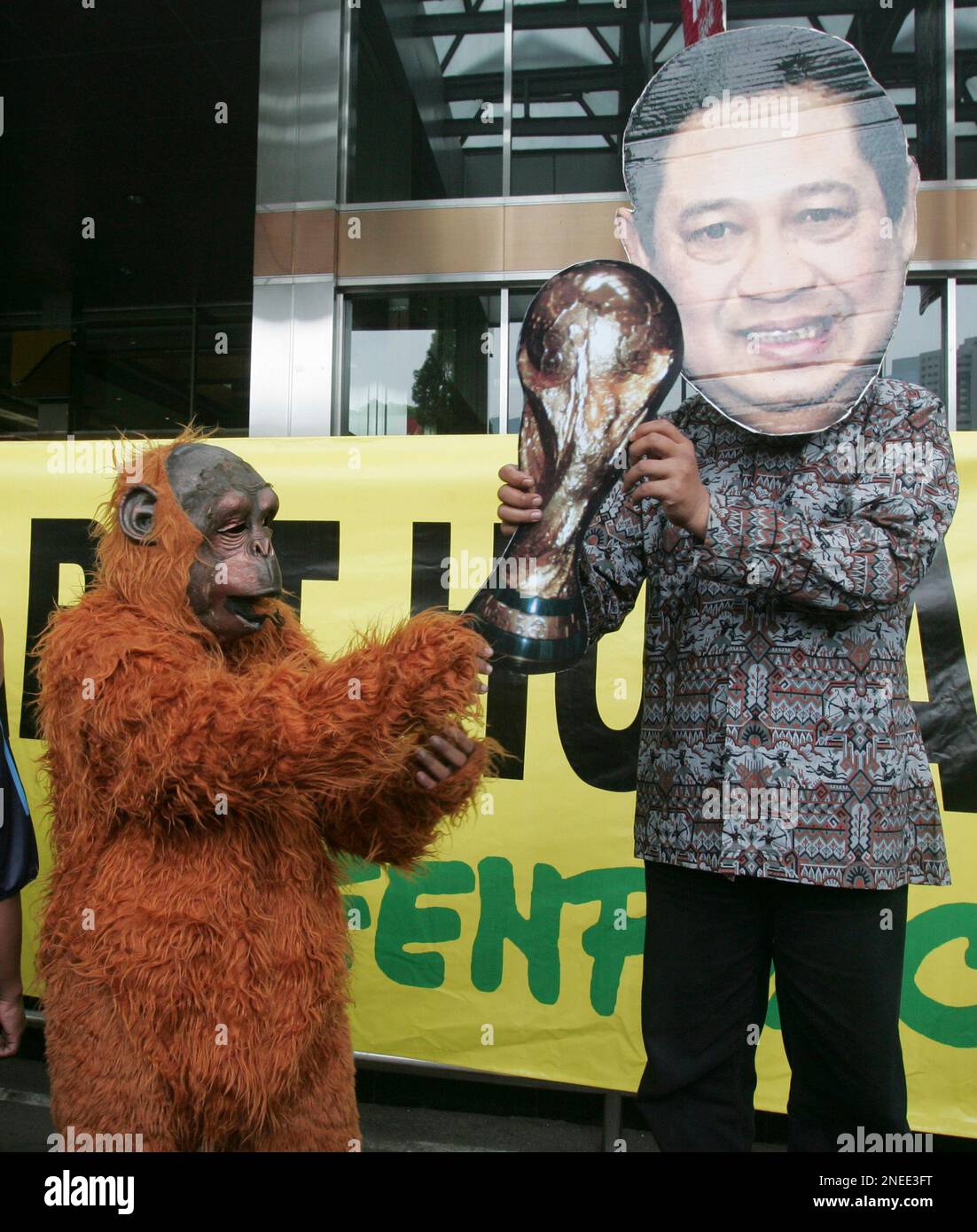 A Greenpeace activist wearing orangutan costume hands a mock FIFA World ...