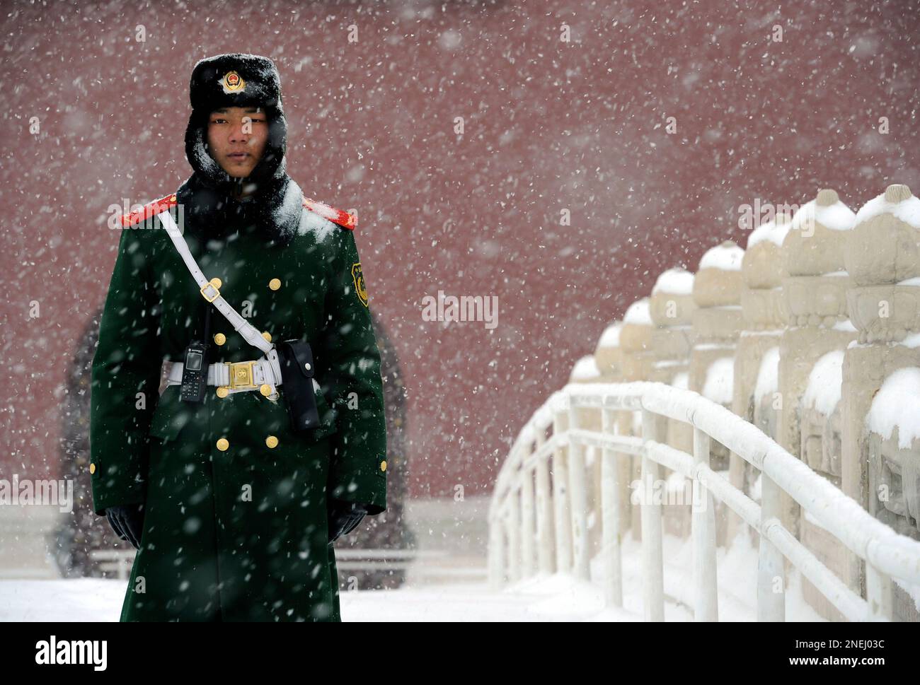 A Chinese paramilitary police officer stands guard during a snow storm ...