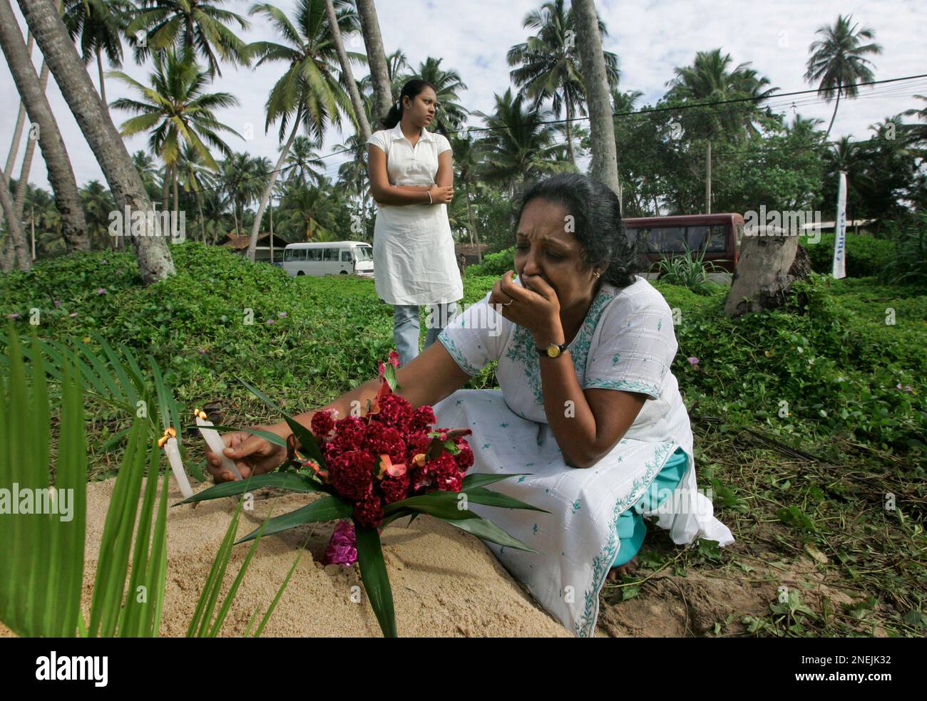 Sri Lankan tsunami survivors pay tribute to a mass grave on the fifth ...