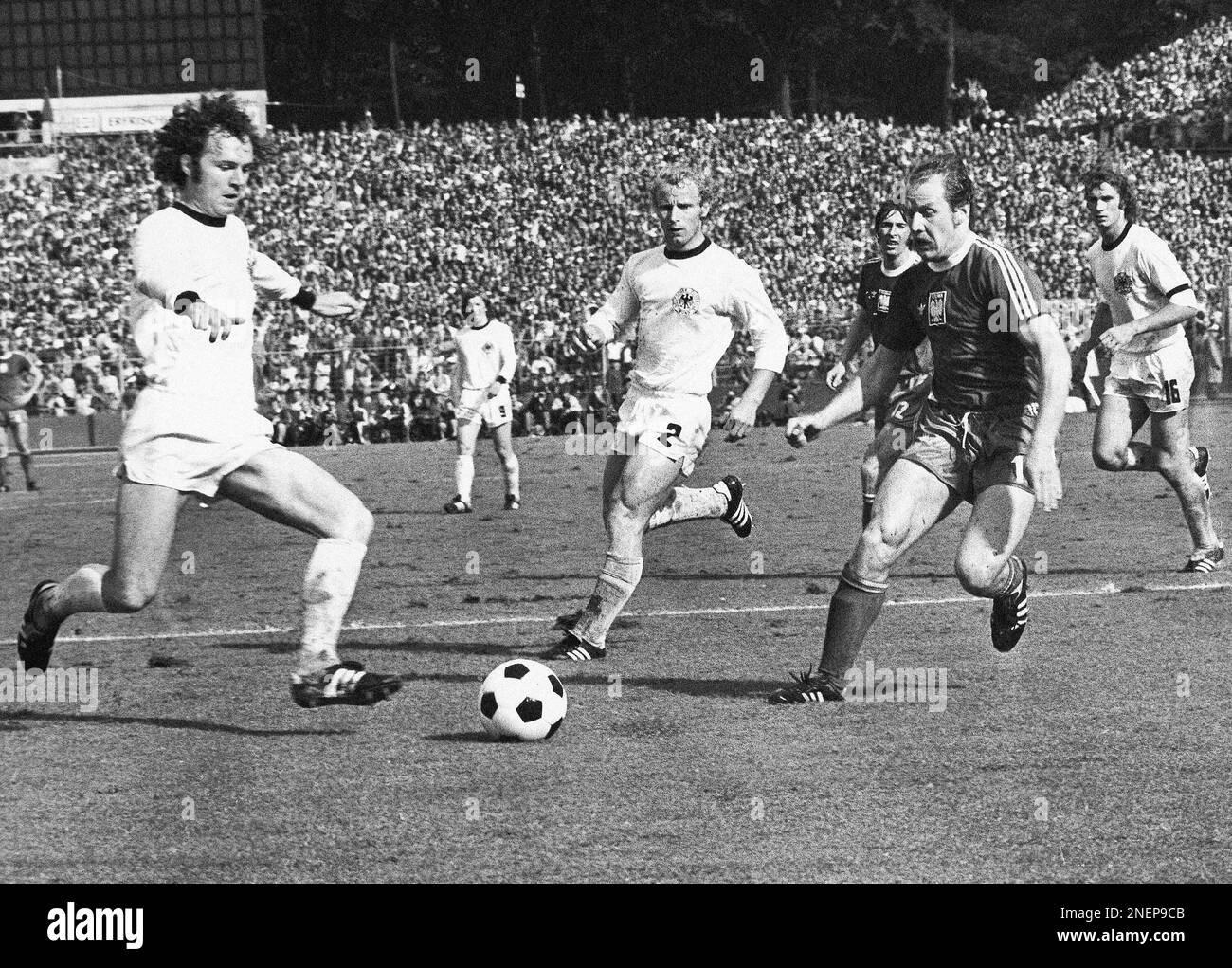 West Germany's captain Franz Beckenbauer, left, kicks the ball away ...