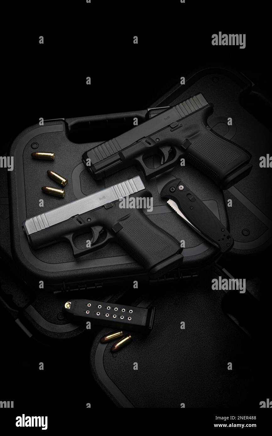 Deux pistolets, 9mm cartouches et un couteau sont situés sur un étui en plastique. Kit d'auto ...