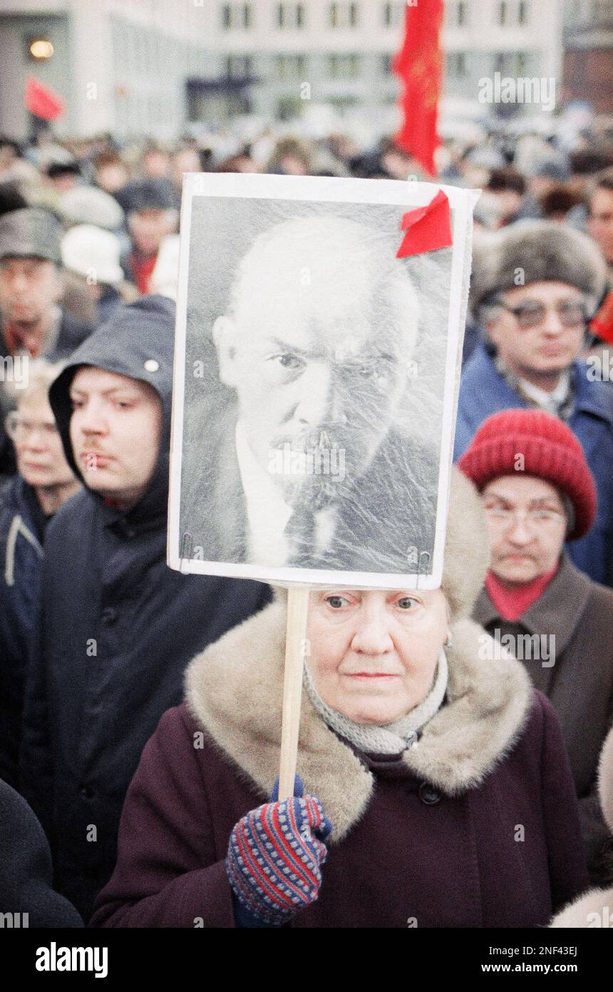 A pro-communist hardliner holds up a picture of Vladimir Lenin, founder ...