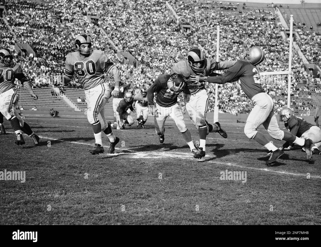 Skeet Quinlan, Los Angeles Ram halfback gives a hard straight arm to ...