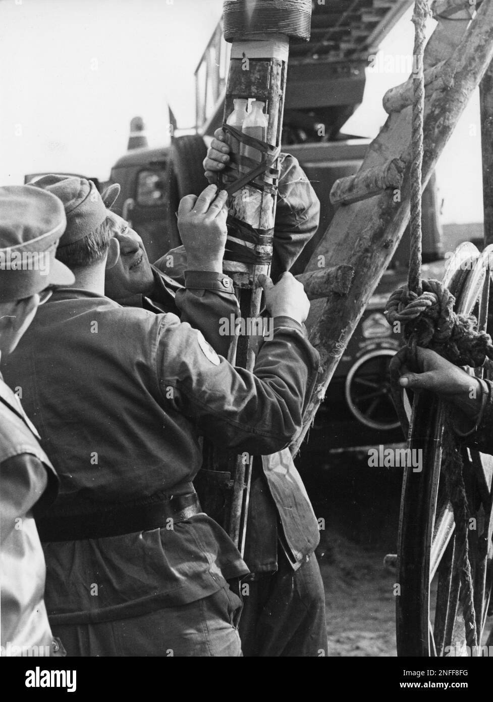 A group of rescue workers prepare a capsule with food and bewerages to ...