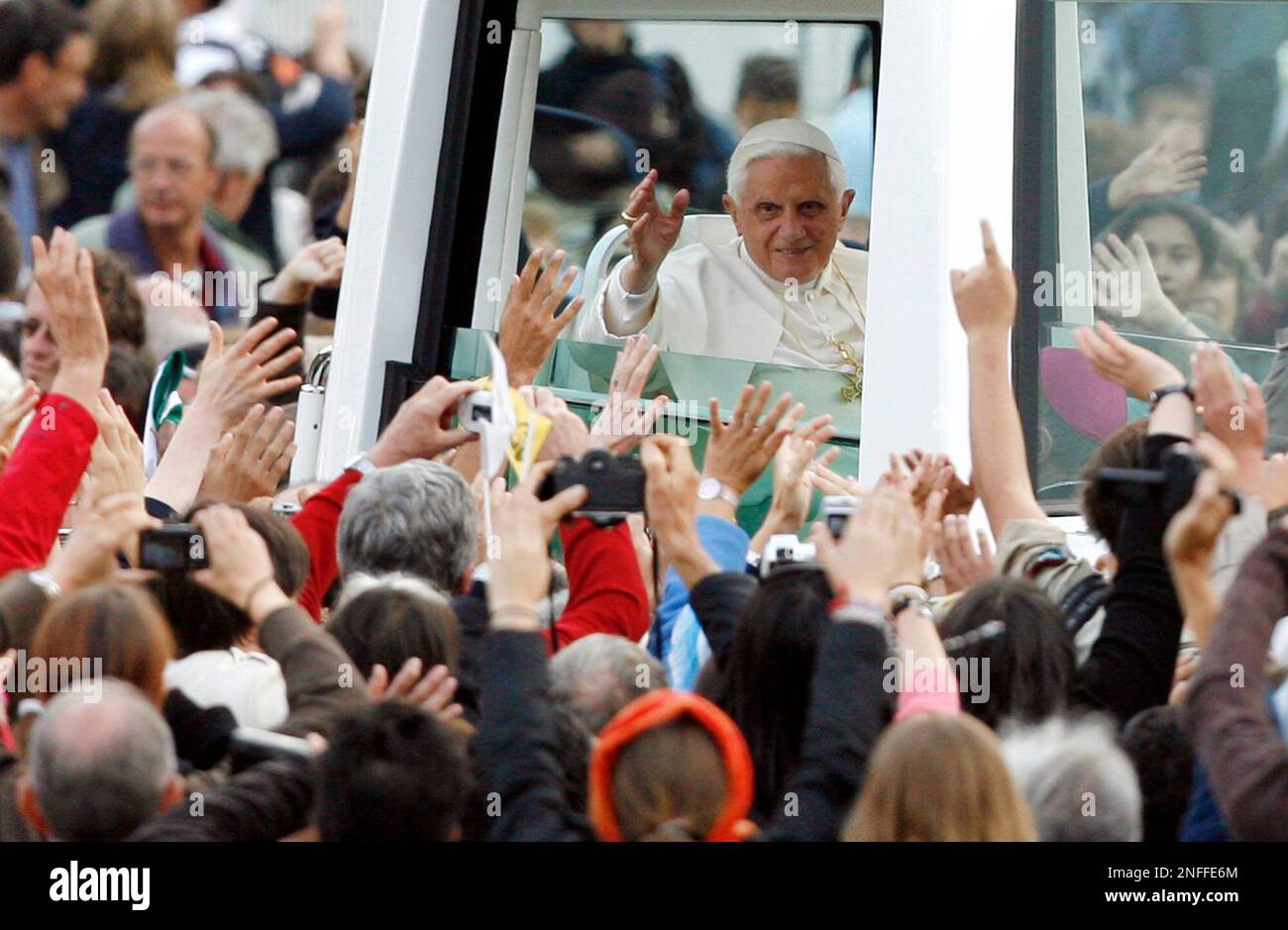 Pope Benedict XVI waves to the crowd from his popemobile after taking ...