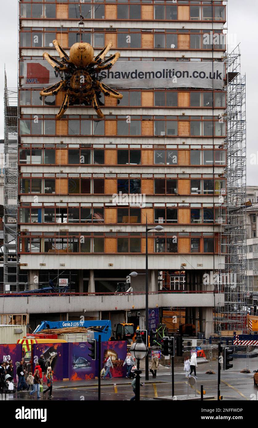 A giant mechanical spider hangs from a disused building in the centre ...