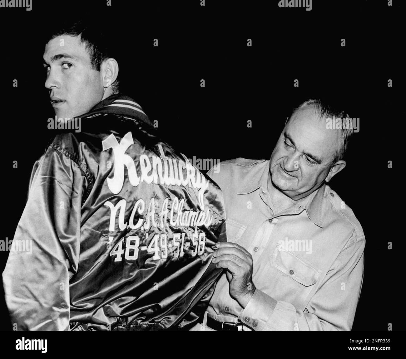 University of Kentucky coach Adolph Rupp looks over the jacket worn by ...