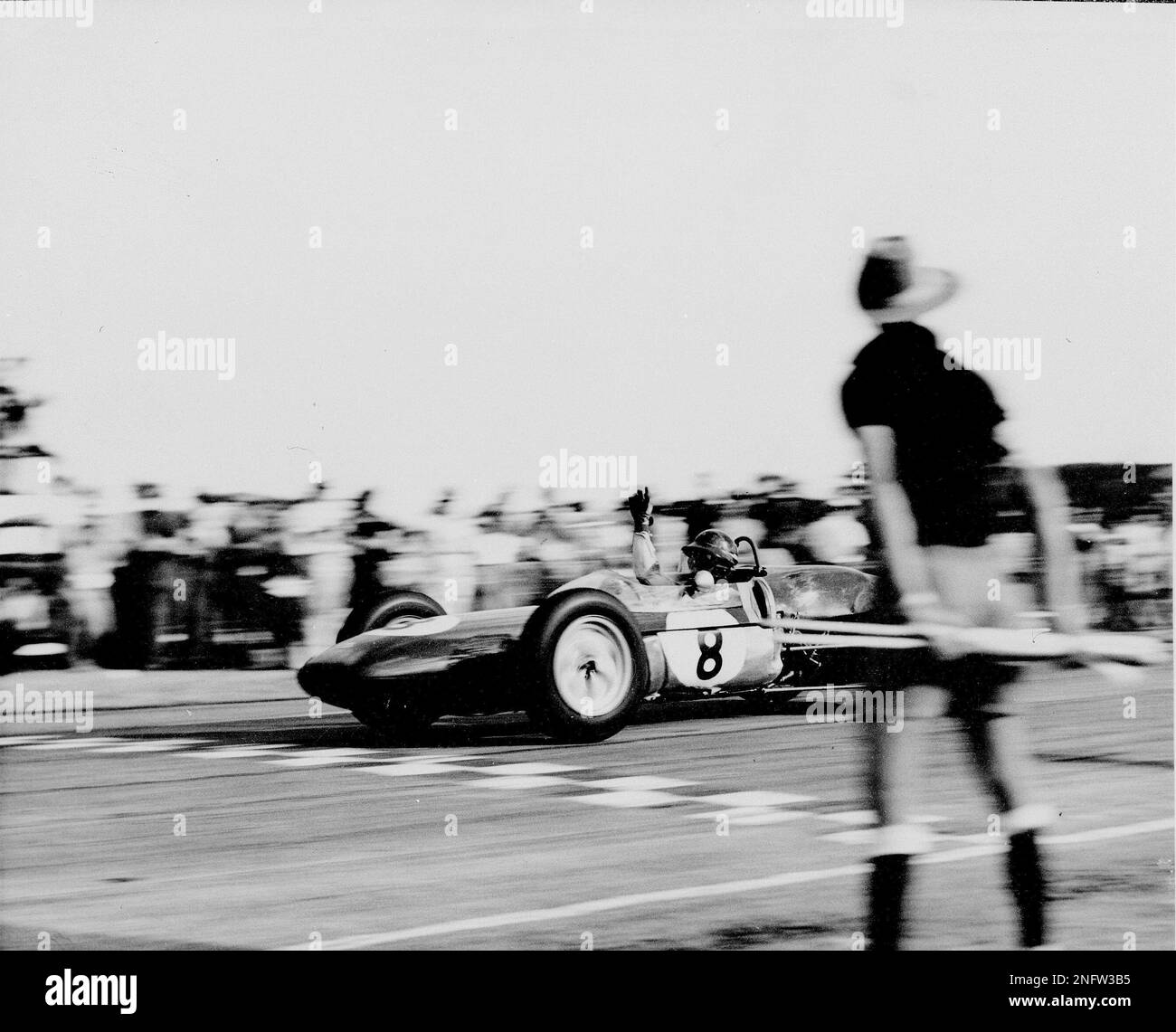 British auto racer Jim Clark waves from the cockpit of his Lotus Climax ...