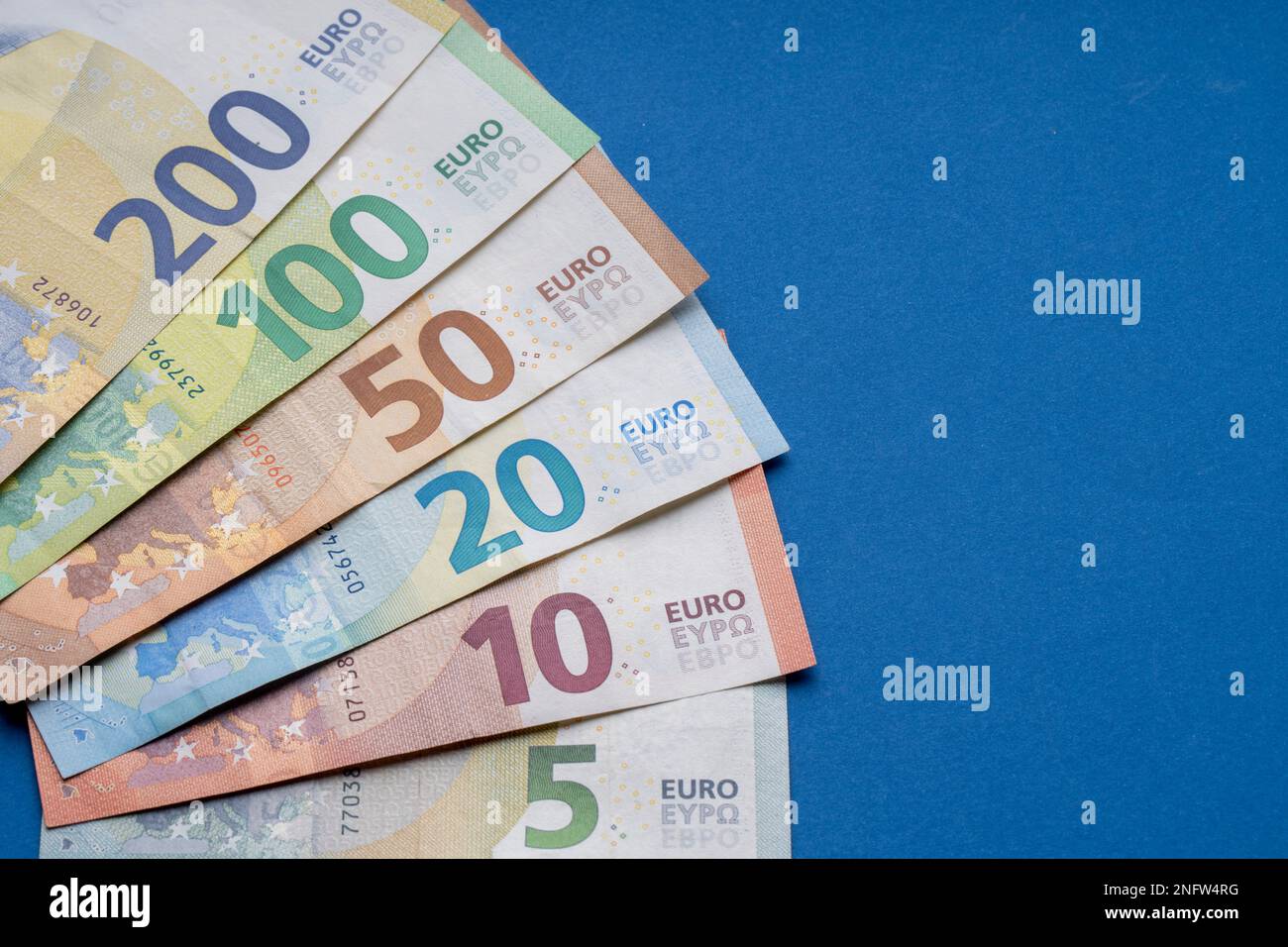 Différents billets en euros dans une ligne de gros plan, fond bleu pour ...