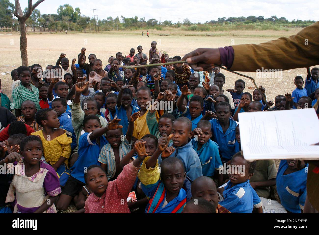 Malawi schoolchildren listen to the teacher from their outdoor ...