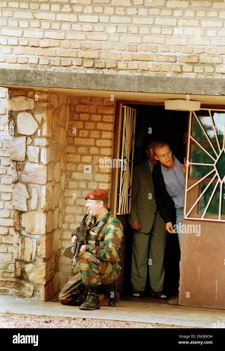 A Belgian soldier guards the front of a house, where Belgians wait to ...