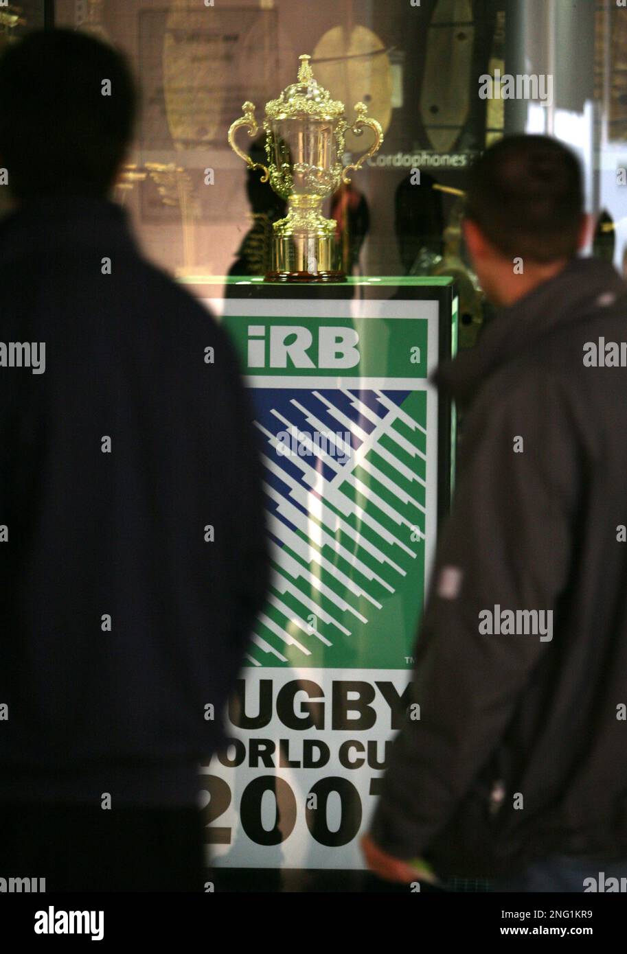 Visitors walk past the Webb Ellis Cup shown at the Quai Branly museum ...