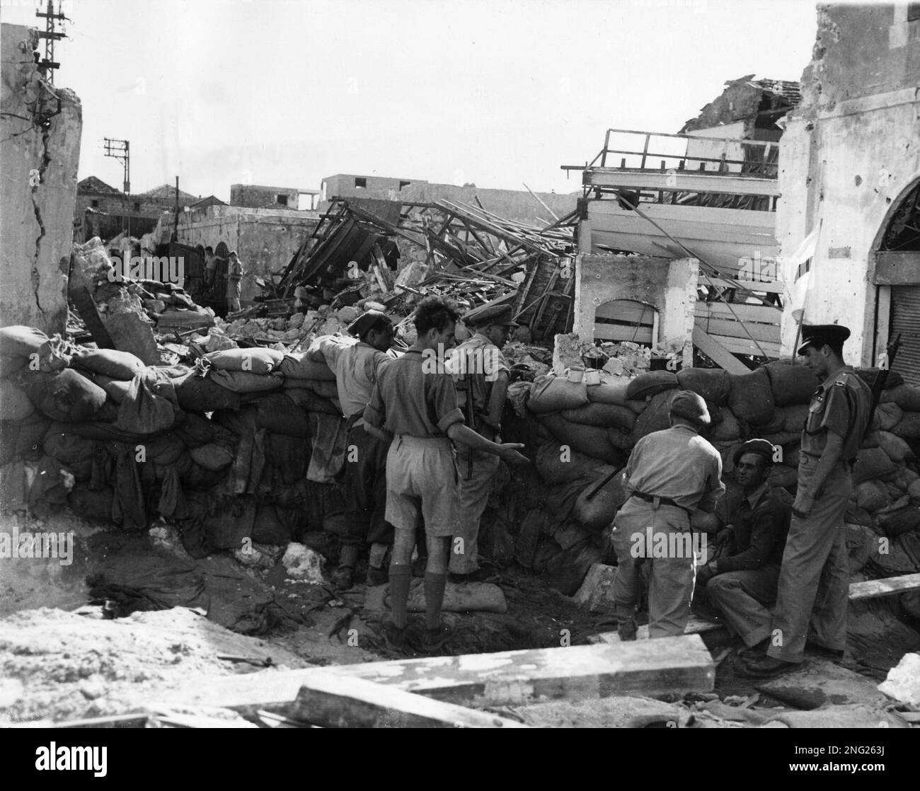 Jewish Haganah troops are seen behind fortifications in the foreground ...