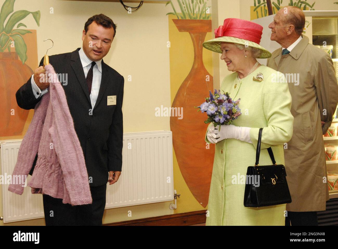 Tim Mead presents Britain's Queen Elizabeth II with a cardigan as she ...