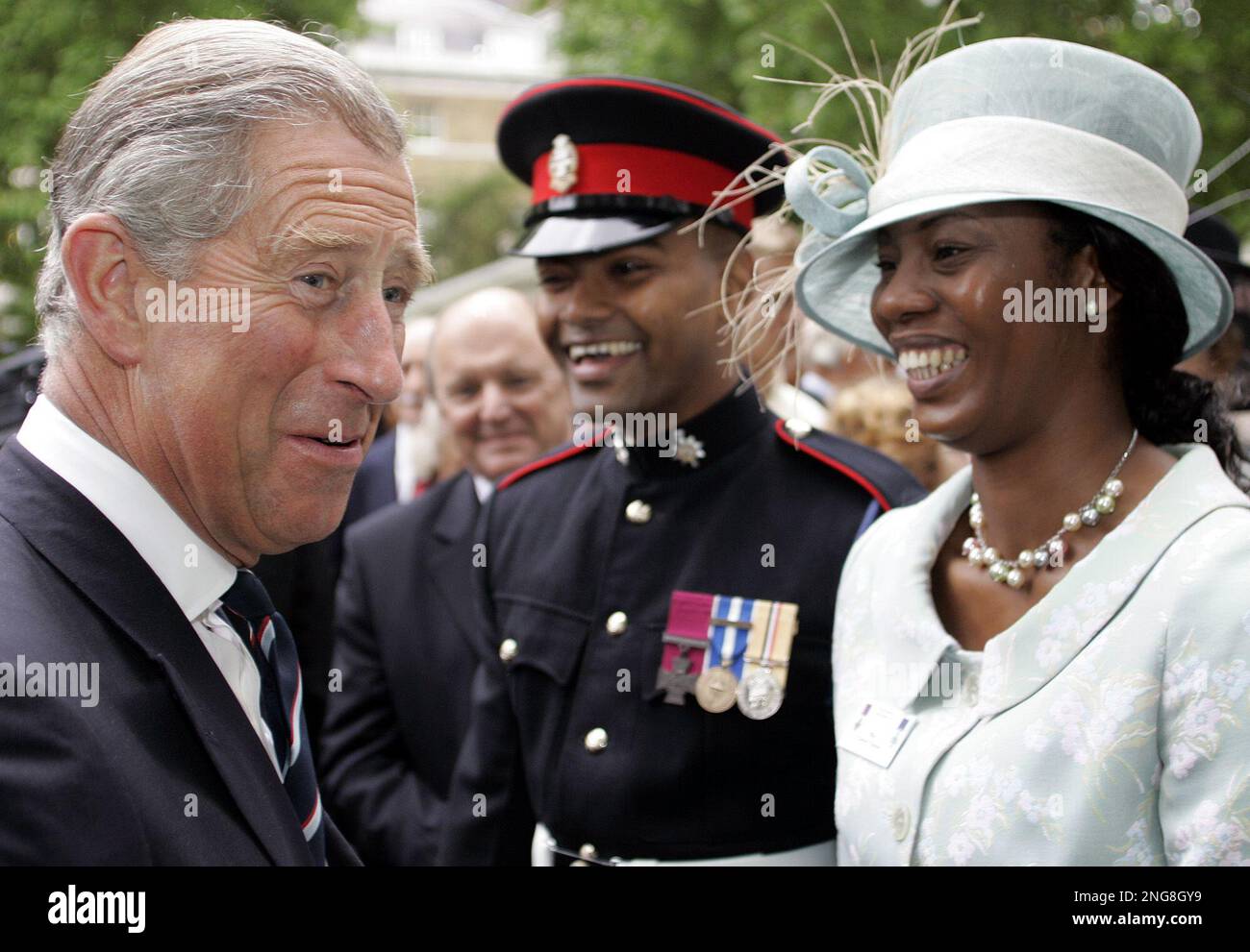 Britain's Prince Charles, left, jokes with Pvt. Johnson Beharry, center ...