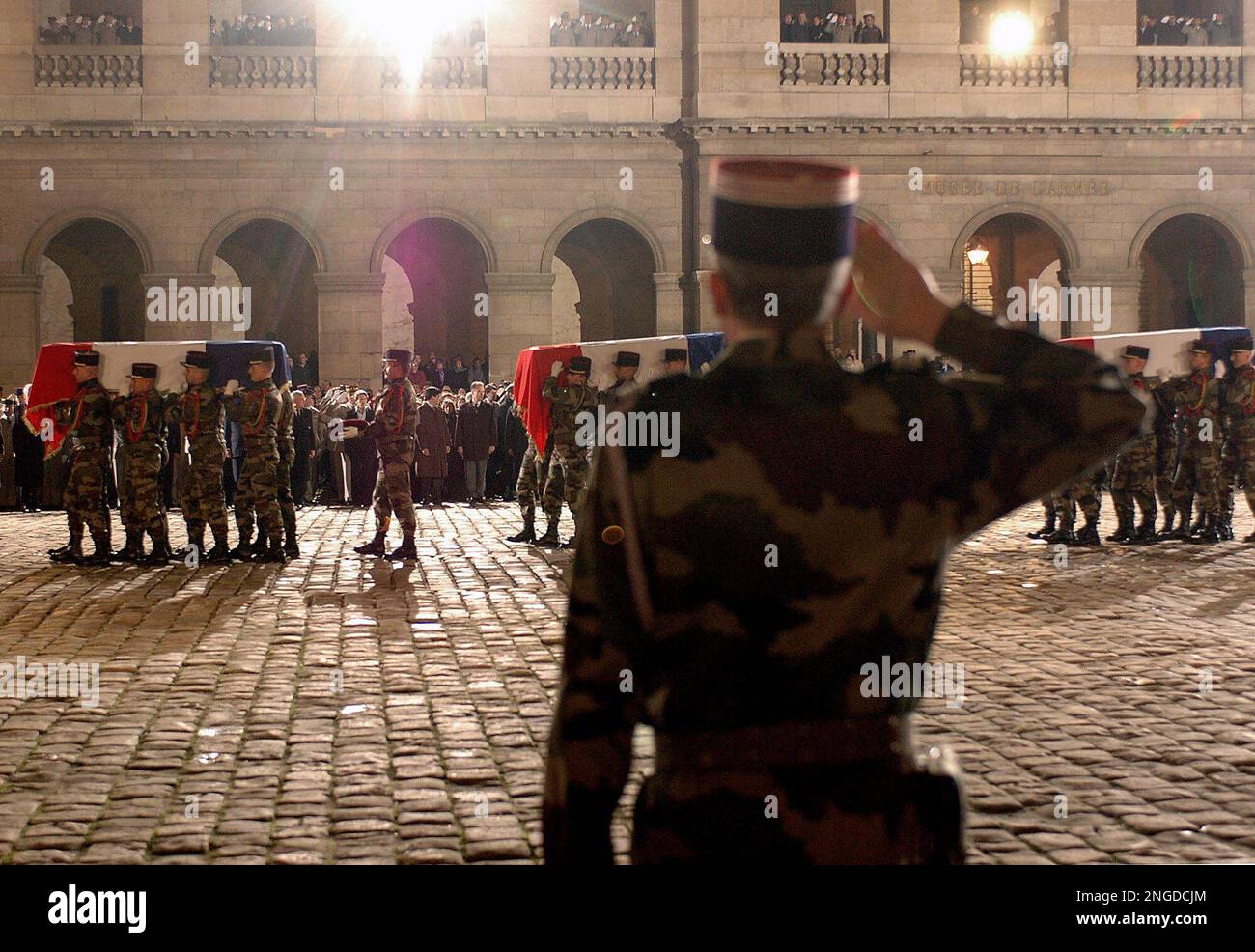 A soldier salutes coffins during the official ceremony for the nine ...