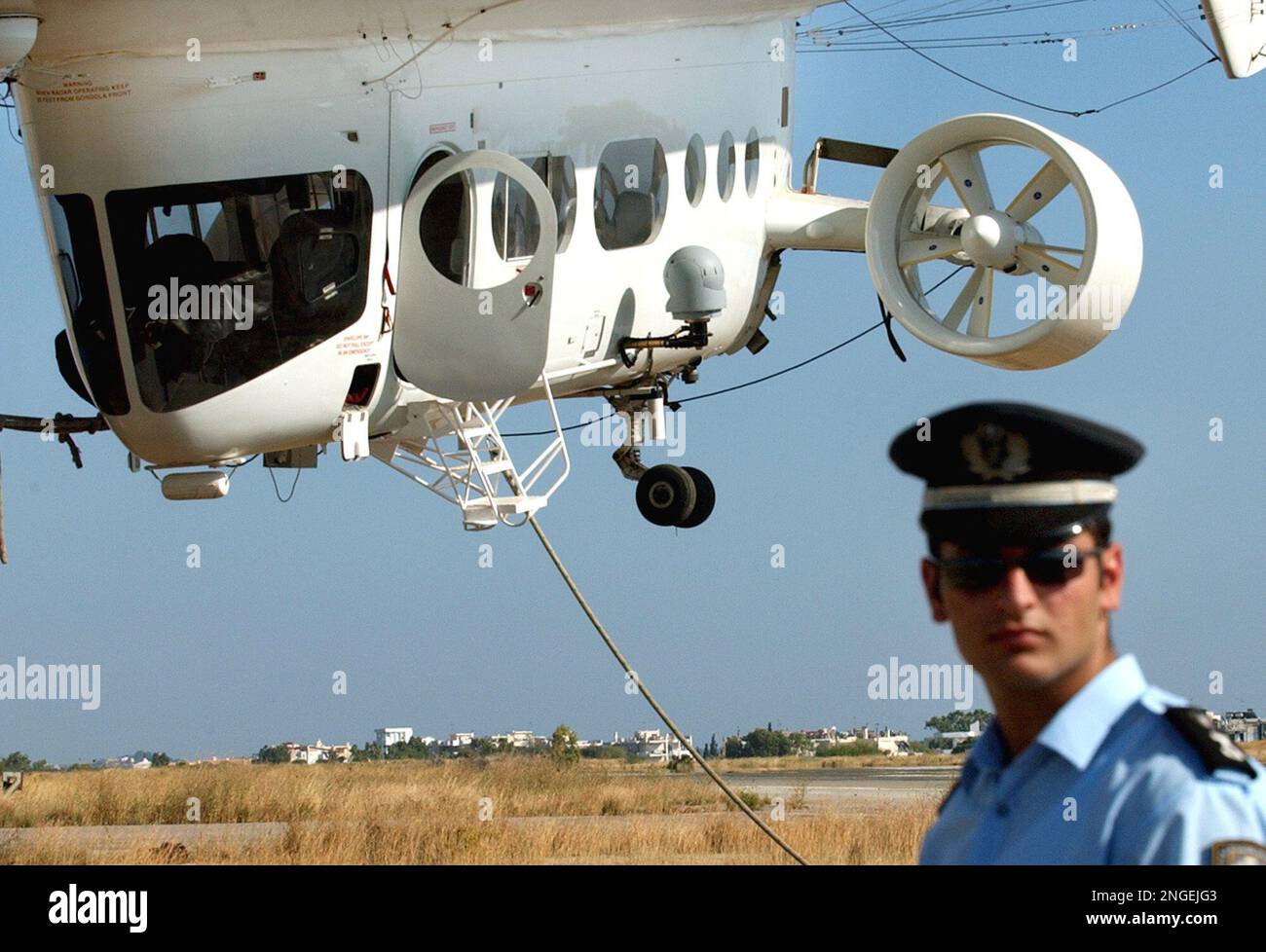 A police officer stands in front of a U.S.-Swiss airship at an old ...