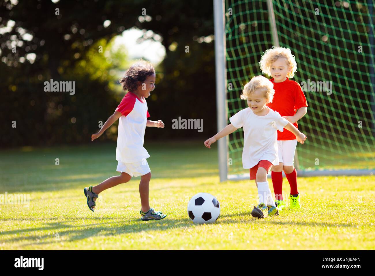 Les enfants jouent au football. Joli petit garçon jouant au football ...
