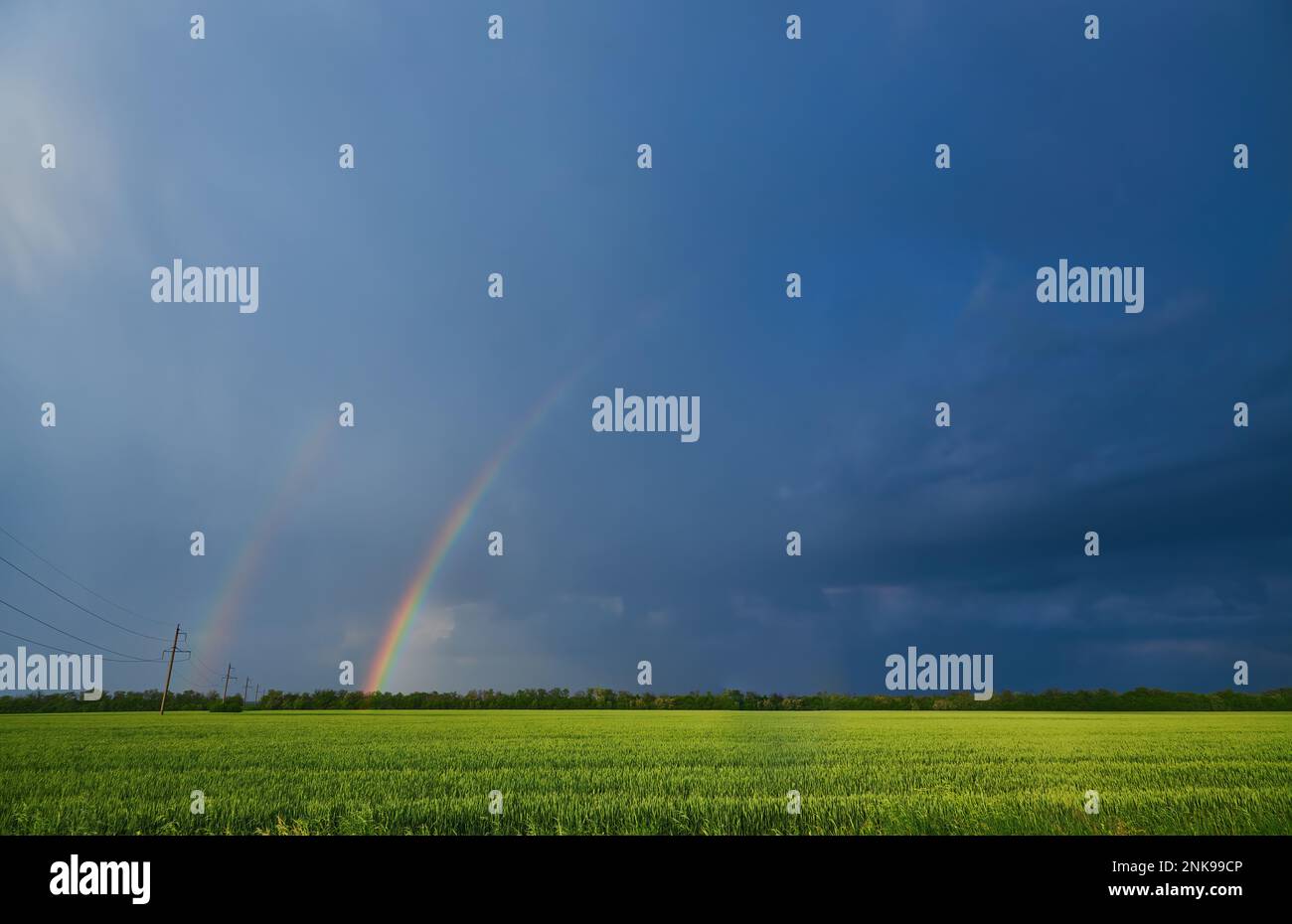 Arc-en-ciel double, coloré et lumineux, devant des nuages sombres au ...