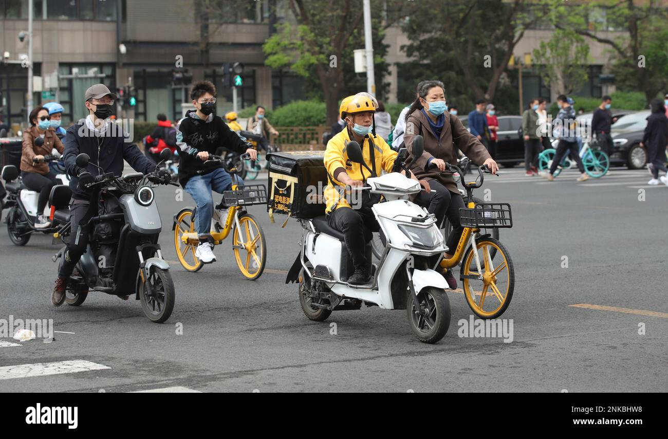 A staff of Meituan (yellow jacket) rides a bike in Beijing, China on ...