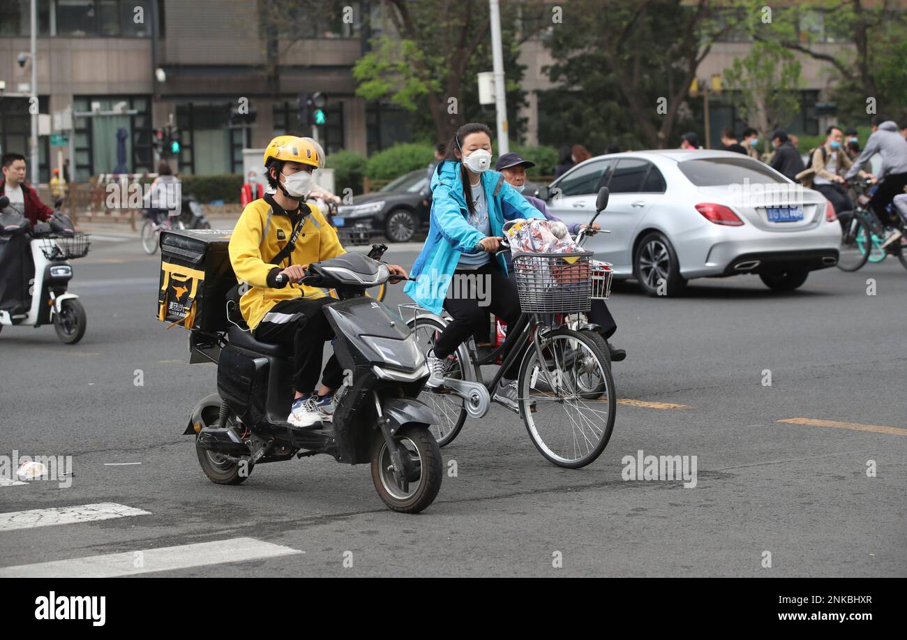 A staff of Meituan (yellow jacket) rides a bike in Beijing, China on ...
