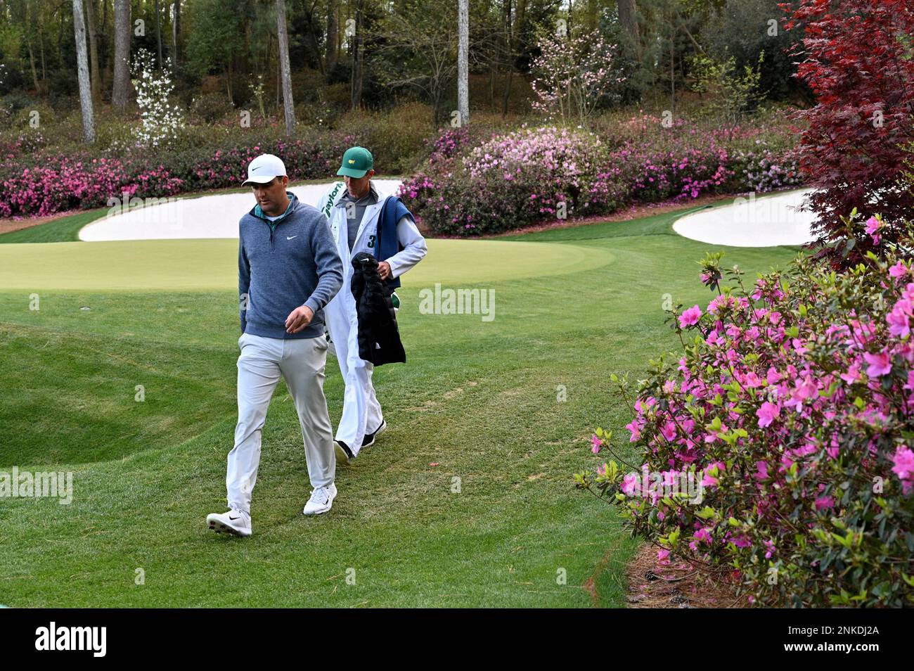 Scottie Scheffler walks to the 14th tee with his caddie, Ted Scott ...