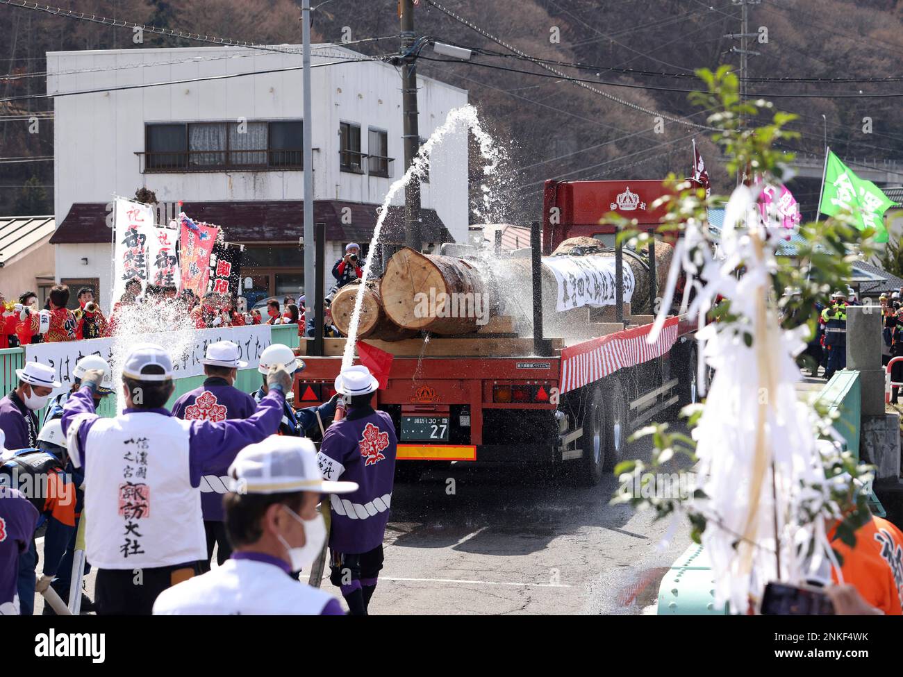 Huge trees are carried by a trailer truck for Onbashira Matsuri, also ...