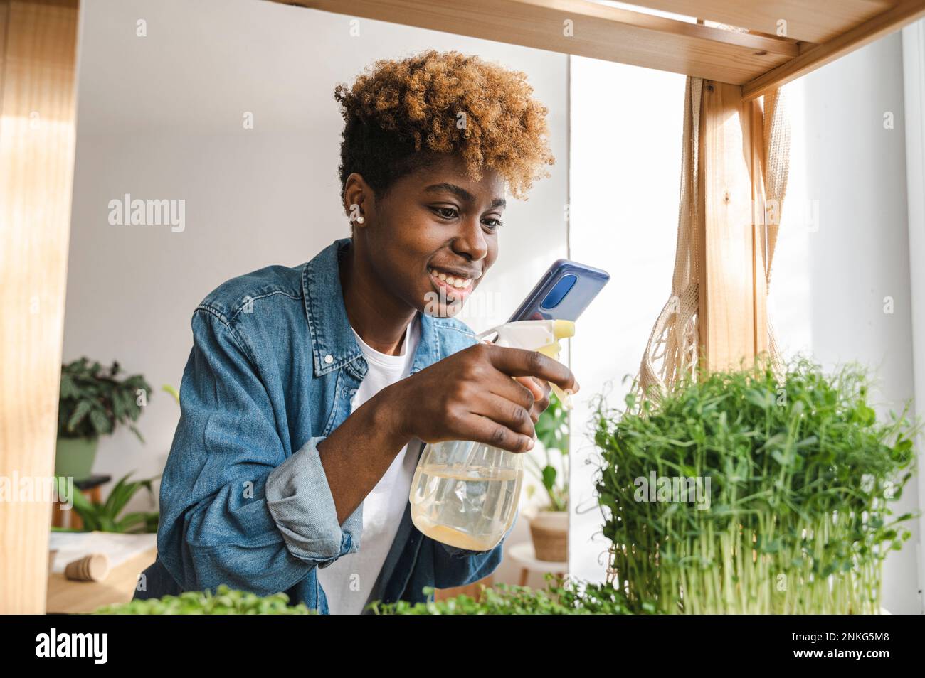 Un influenceur souriant vaporise de l'eau sur les plantes et se moque ...