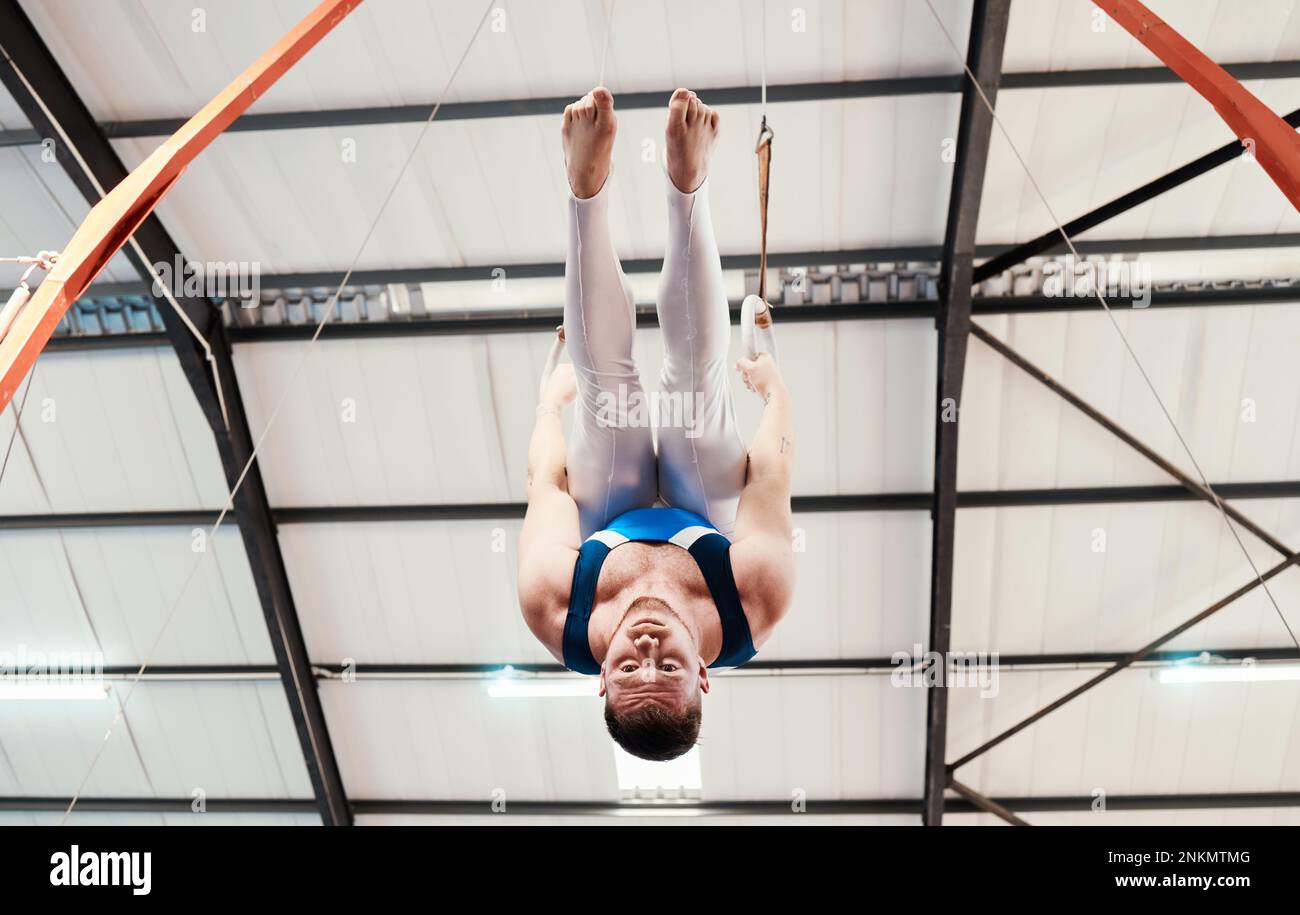 Homme, acrobat et gymnastique à l'envers sur les anneaux en forme ...