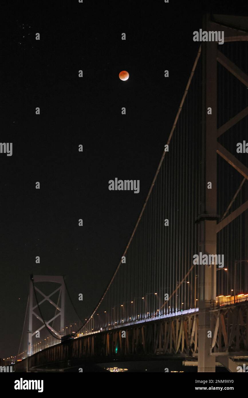 A photo shows a partial lunar eclipse seen above the Onaruto Bridge, a ...