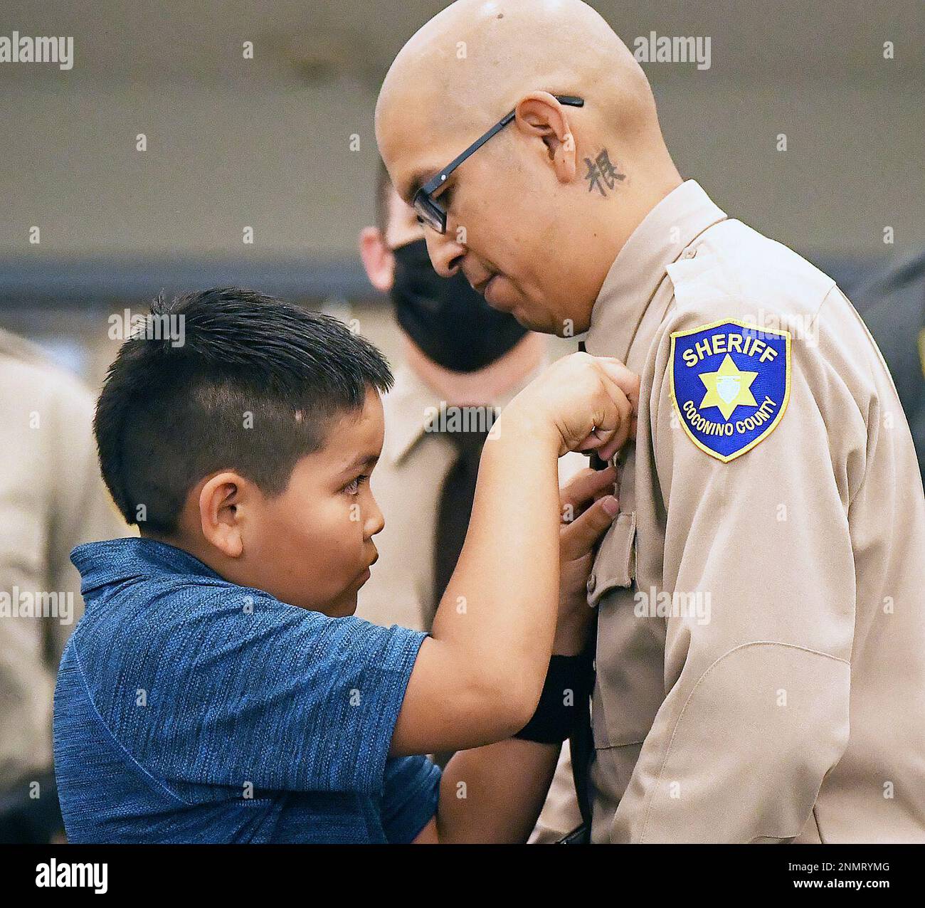 Takoa Ruiz, left, pins his father Oscar Ruiz' badge on him during Arizona Western College Law ...