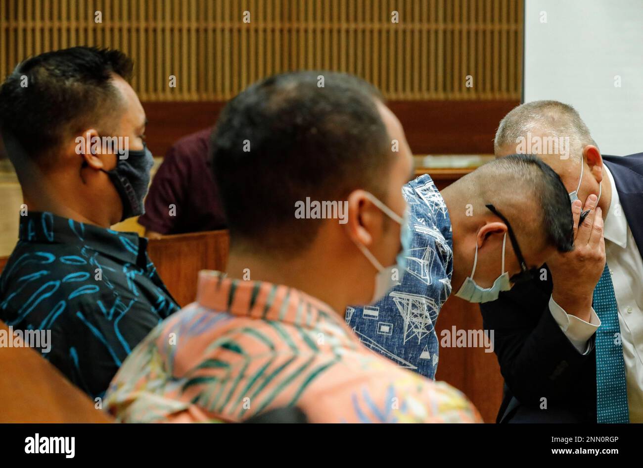 Honolulu police officer Geoffrey Thom, second from right, listens to ...