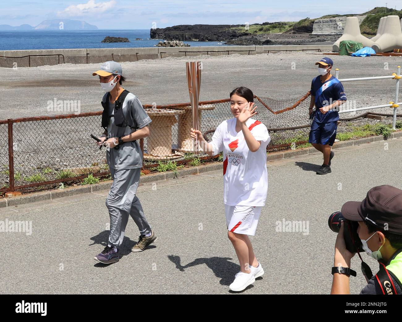 A runner of the Olympic torch relay runs on public roads for the first ...