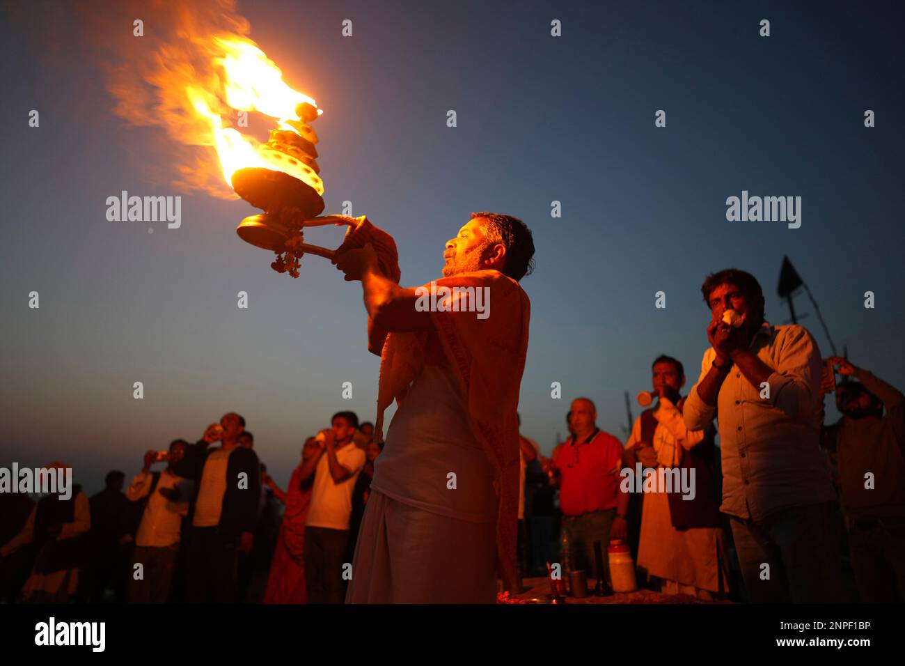 Indian Hindu devotees perform "Aarti" a ritual involving rotating a ...