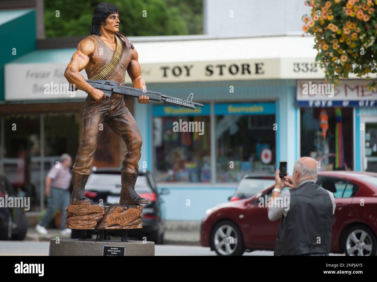 A man takes a photo of a life-size chainsaw cut statue of Sylvester ...