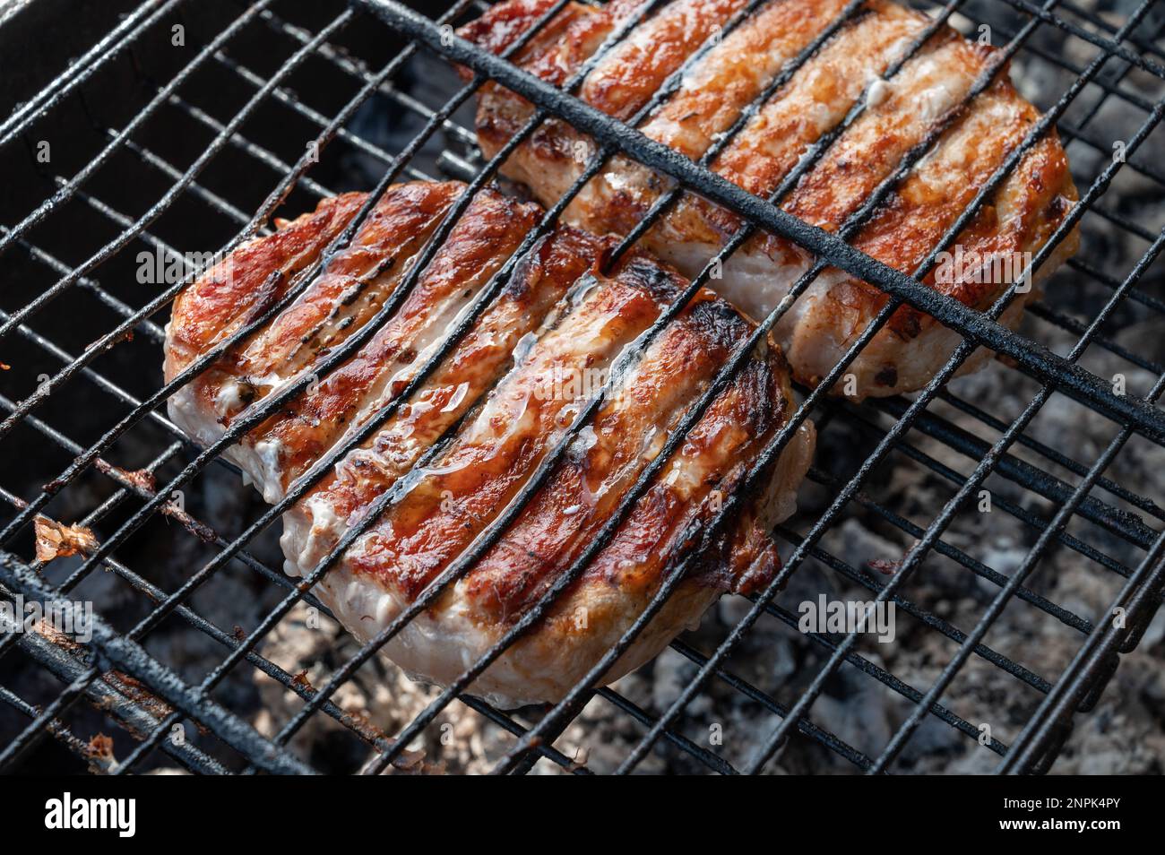 Griller de la viande de porc sur la grille en acier. Concept de repos d ...