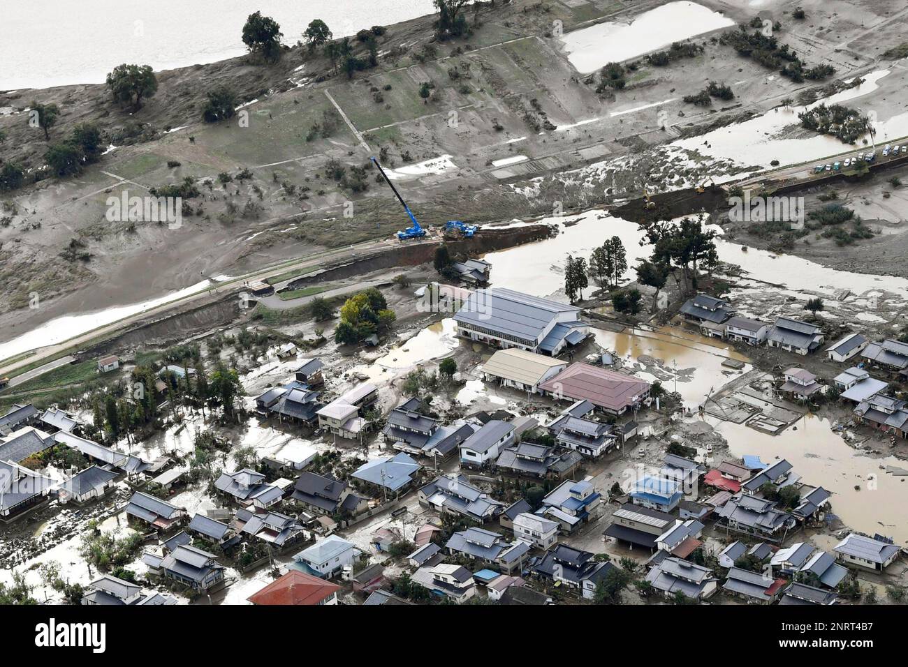 This photo shows a broken embankment, center, of the Chikuma River and ...