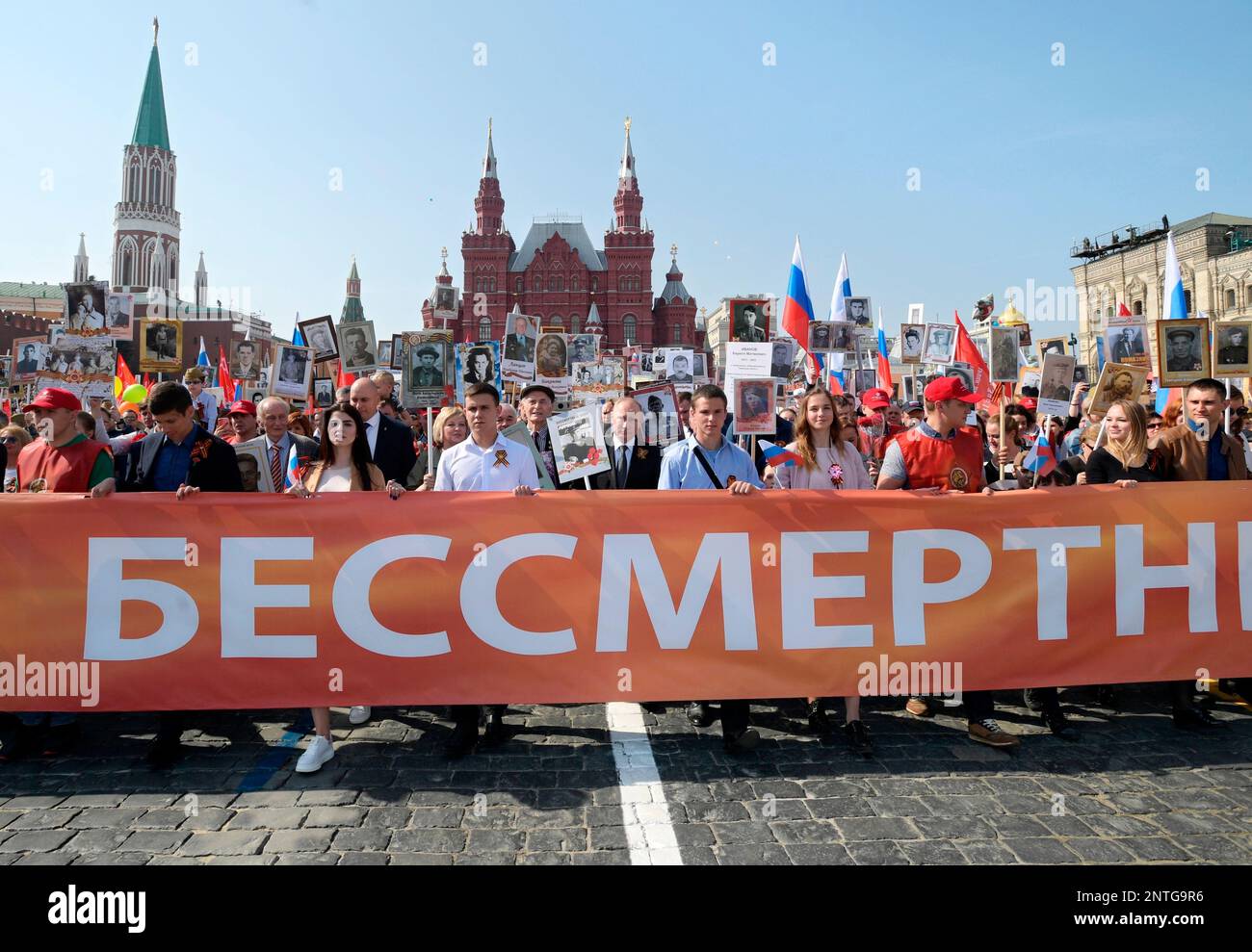 Russian President Vladimir Putin, center, holds a portrait of his ...