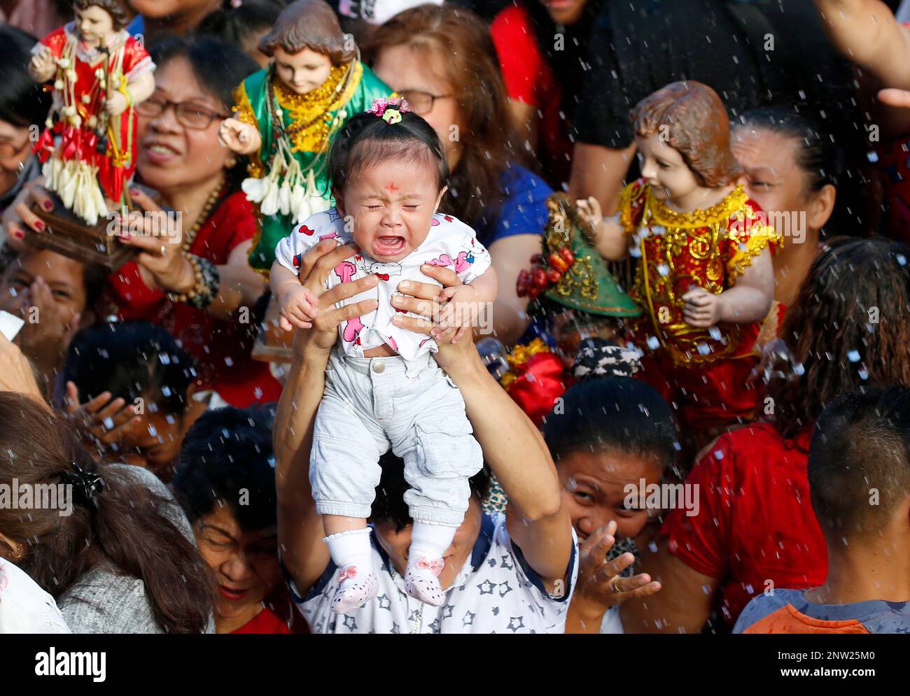 Roman Catholic devotees raise their babies and images of the Child ...