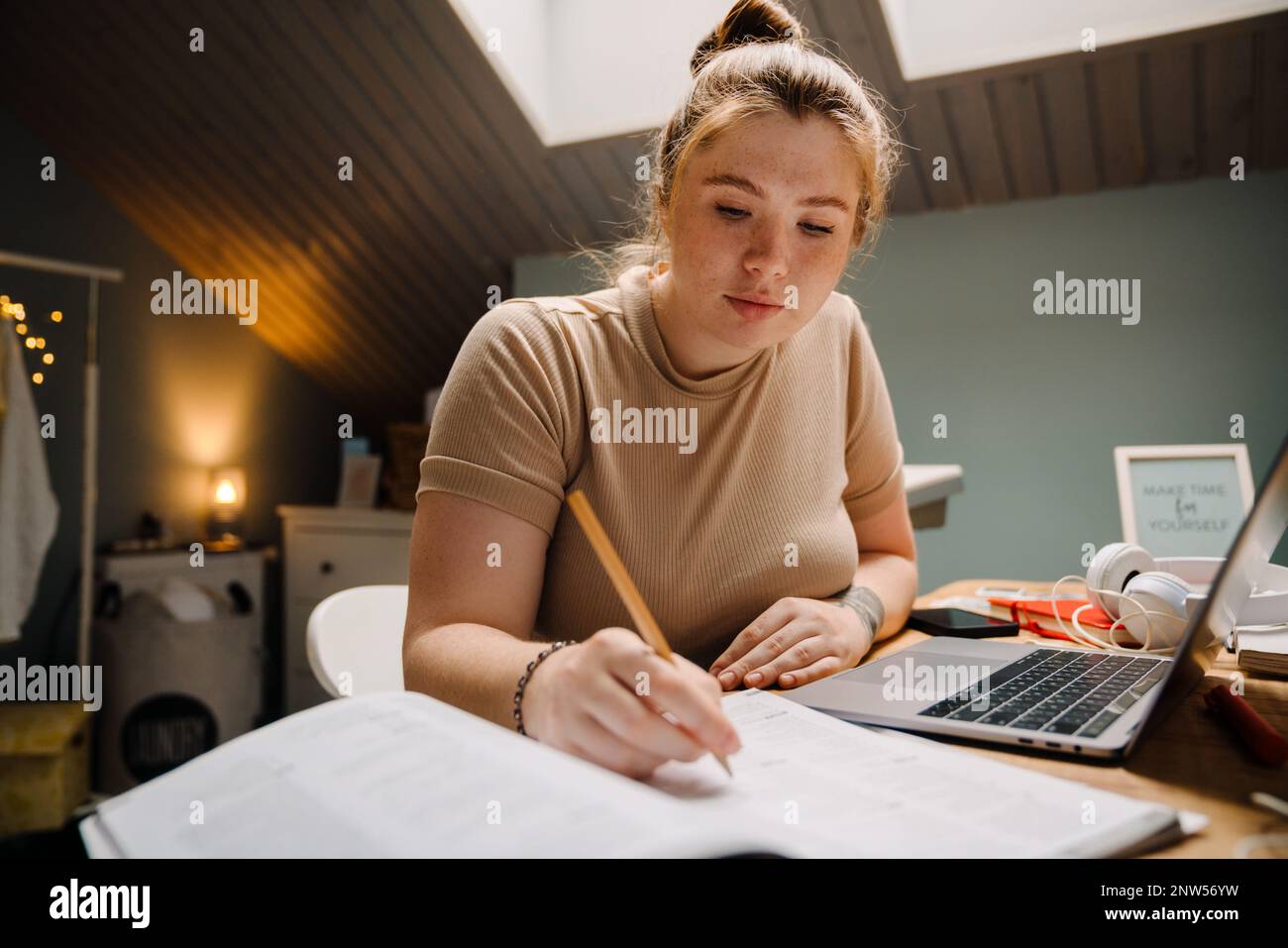 Jeune Fille Très Belle Et Concentrée Qui Fait Ses Devoirs à écrire Avec