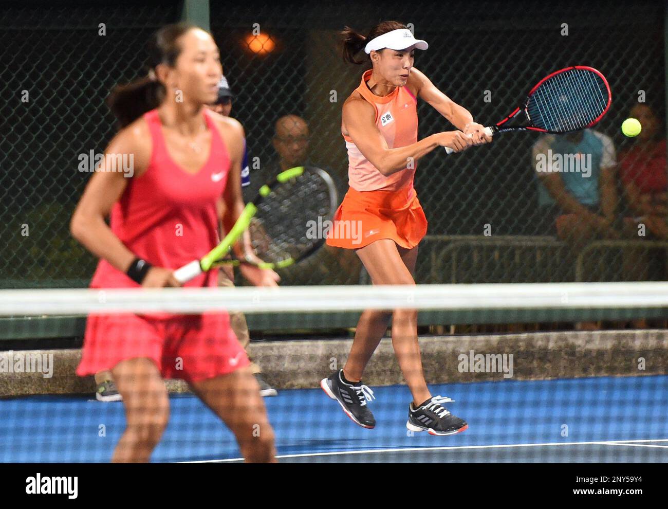 Wang Qiang returns a shot as she and Lu Jiajing of China compete ...