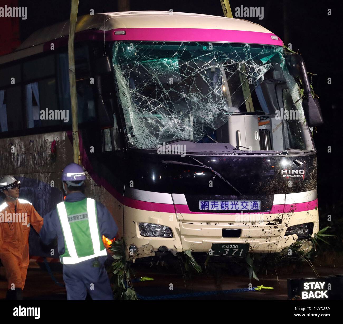 A photo shows a tour bus, being lifted up by a crane after it plunged ...