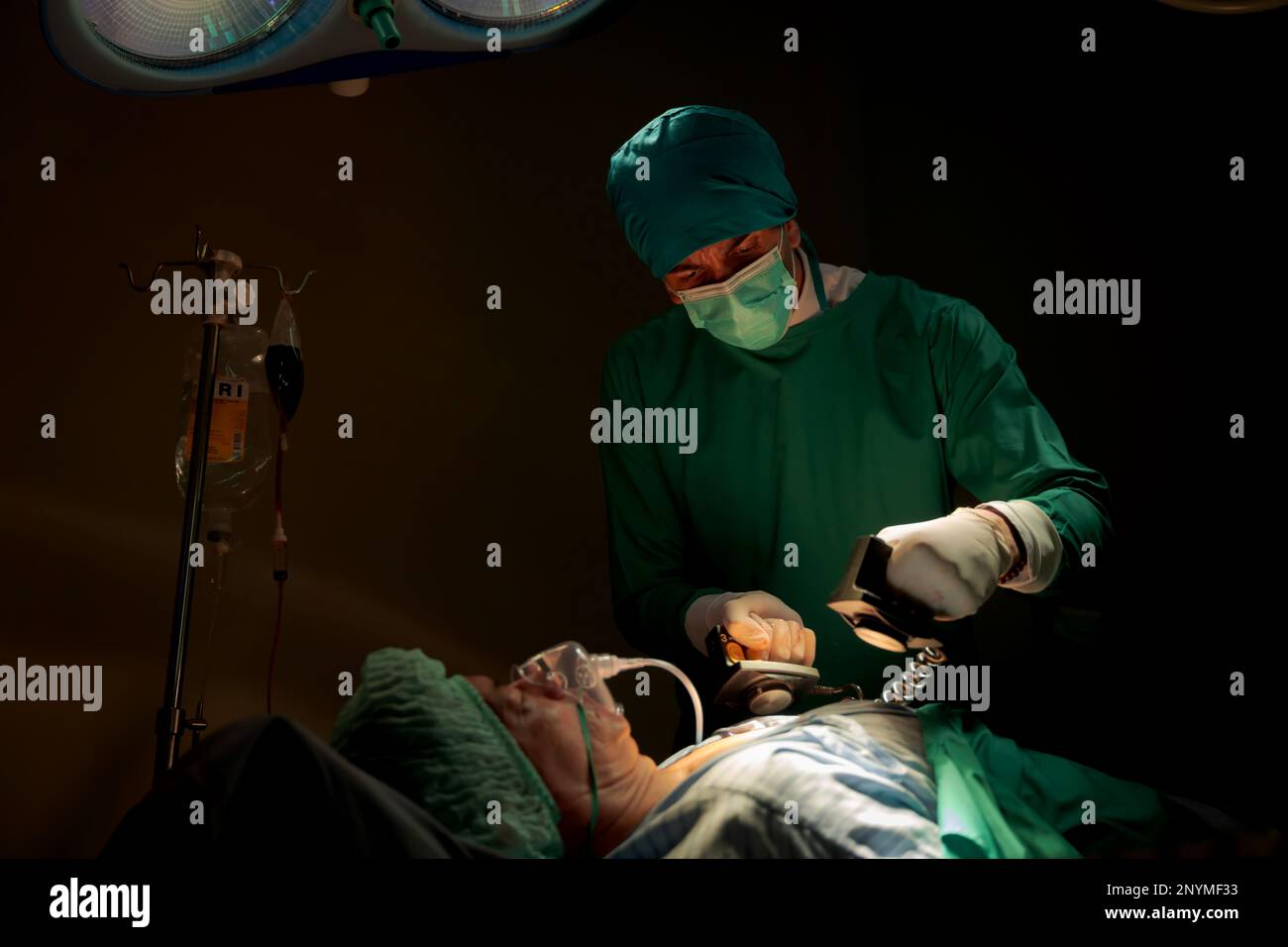 Les médecins d'équipe de la salle d'opération vêtus d'uniformes verts ...