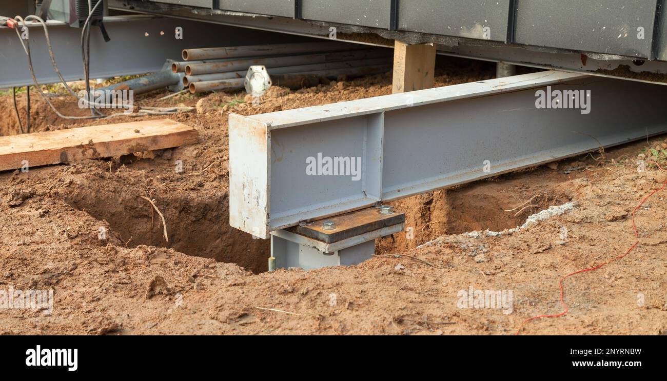 Les fondations en béton supportent les colonnes métalliques. La maison ...
