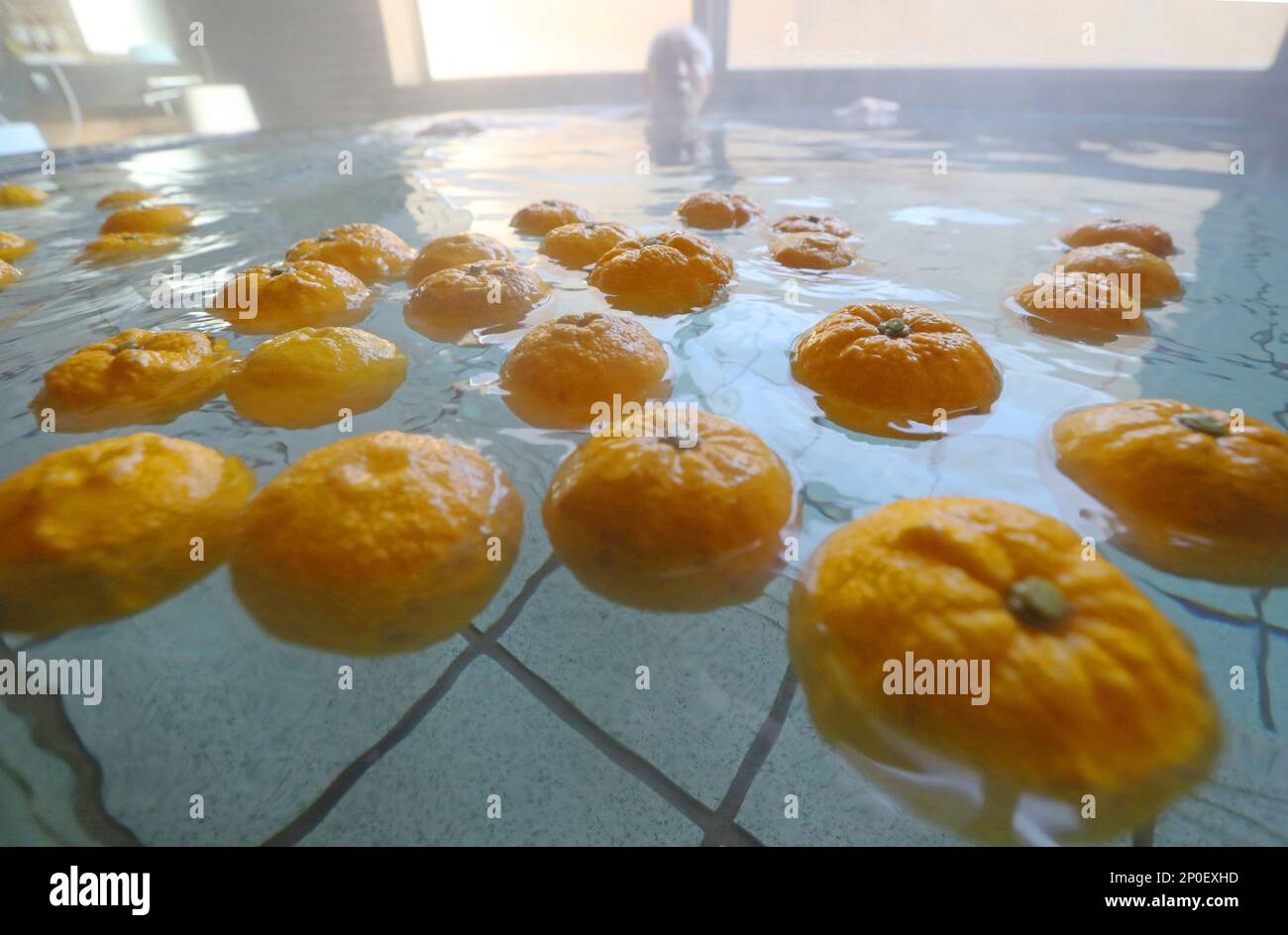 A man takes a yuzu-yu bath steeped with yuzu citrus at a hot spring in Rikuzen-Takata, Iwate ...