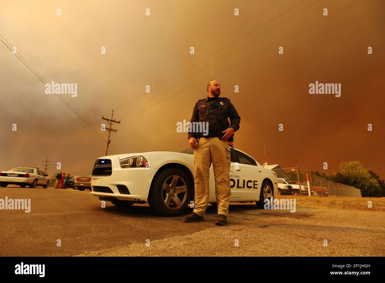 Medicine Lodge, Kan., police officer Todd Geist stands under a cloud of ...