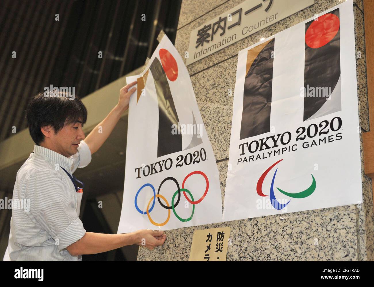 A person of Tokyo Government Office takeing off the controversial logos ...